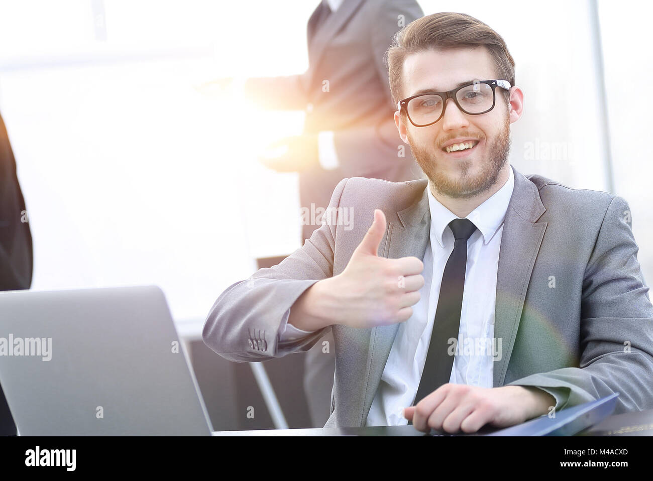 Manager sitting at his Desk and showing thumbs up Stock Photo - Alamy