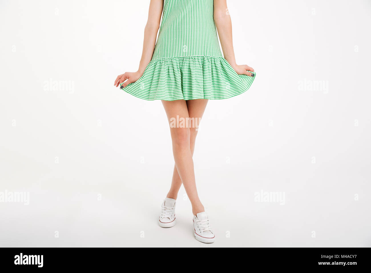 Half body portrait of a young girl in dress posing with legs crossed ...