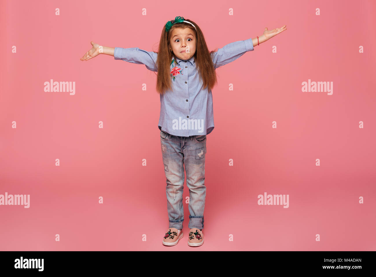 Lovely child girl in hair hoop and casual clothes giving huge hug with ...