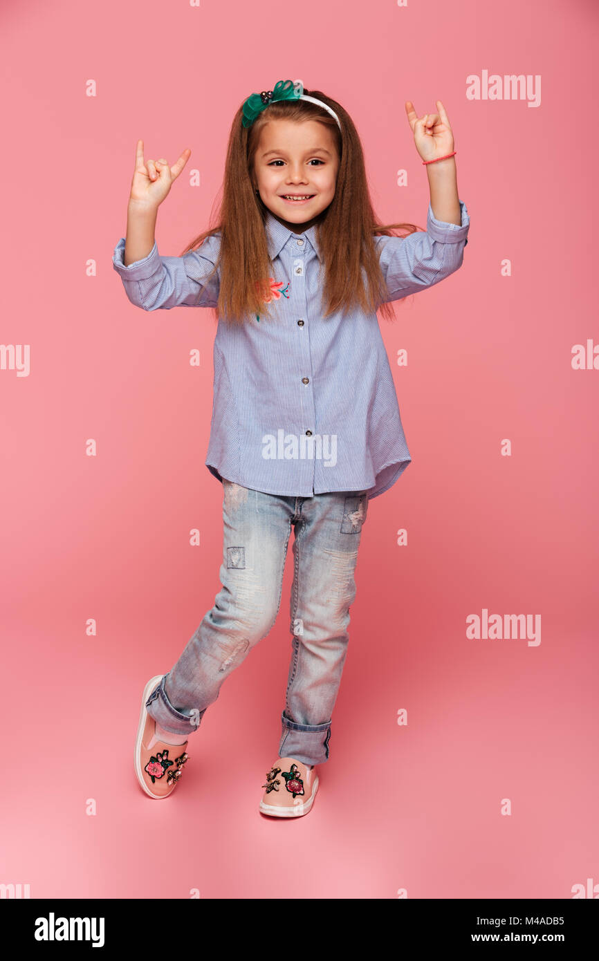 Full-length picture of funny little girl gesturing rock sign with two ...