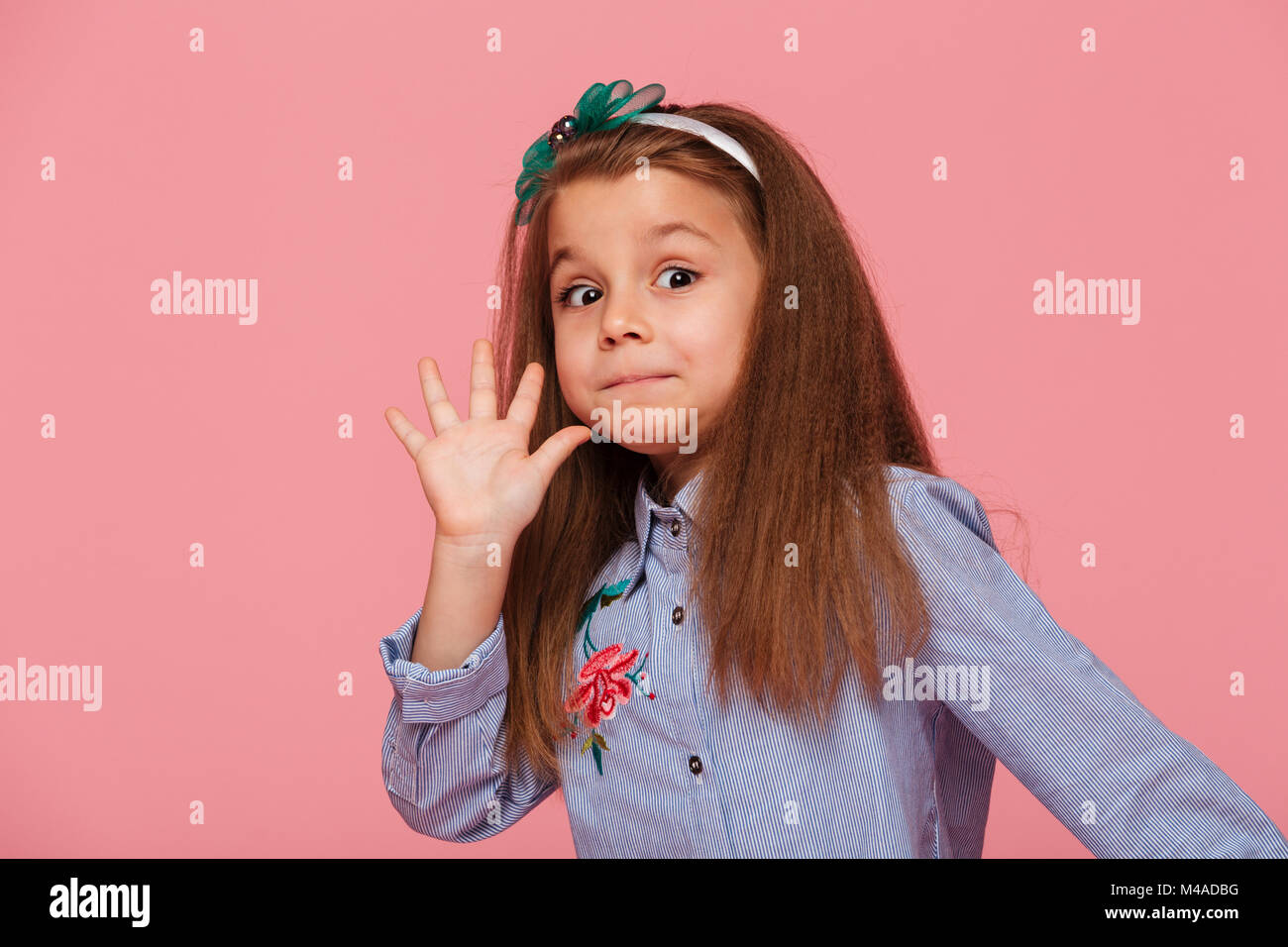 Portrait of funny female kid having long auburn hair looking on camera ...
