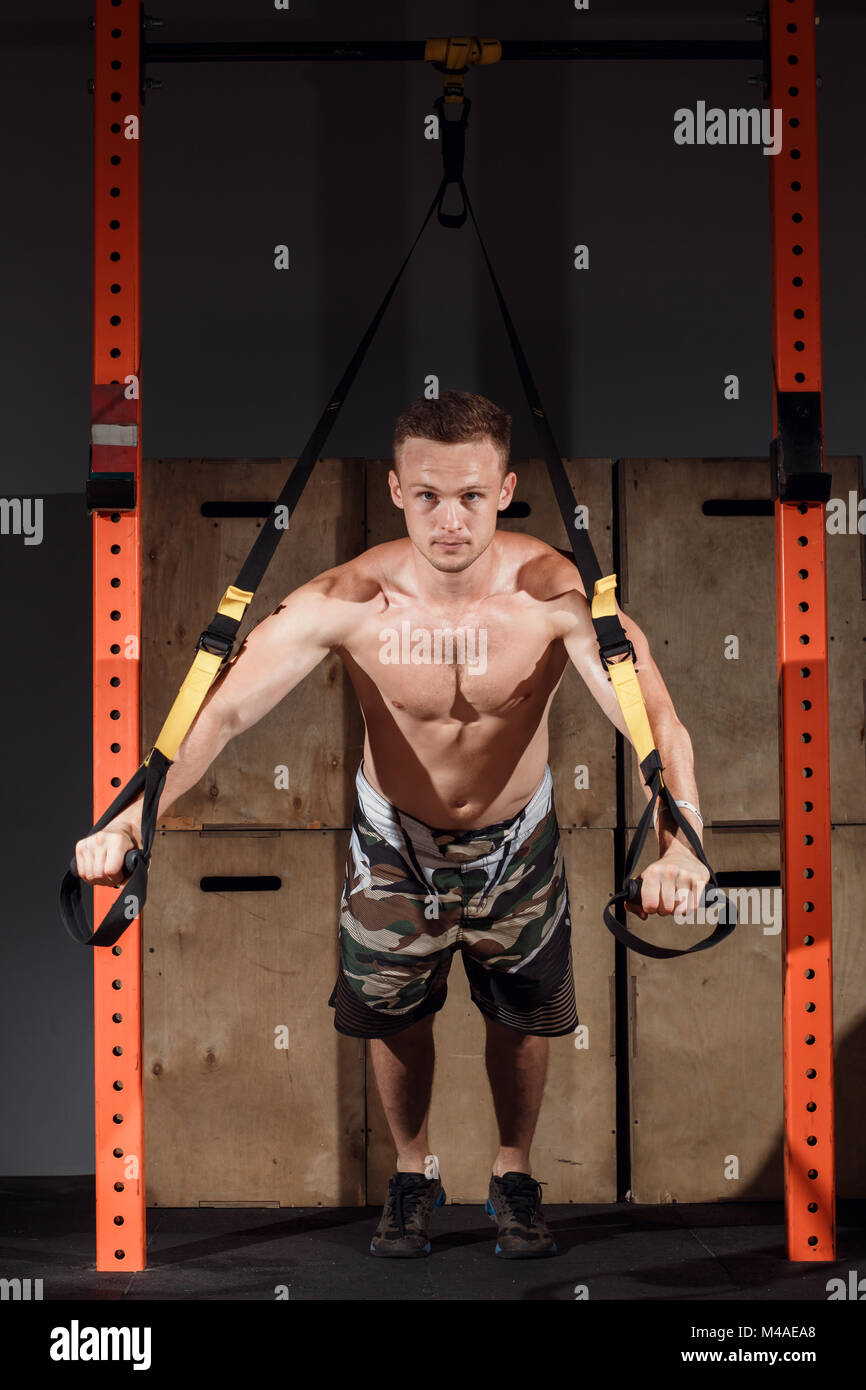 Great TRX workout. Full length of young handsome man in sportswear ...