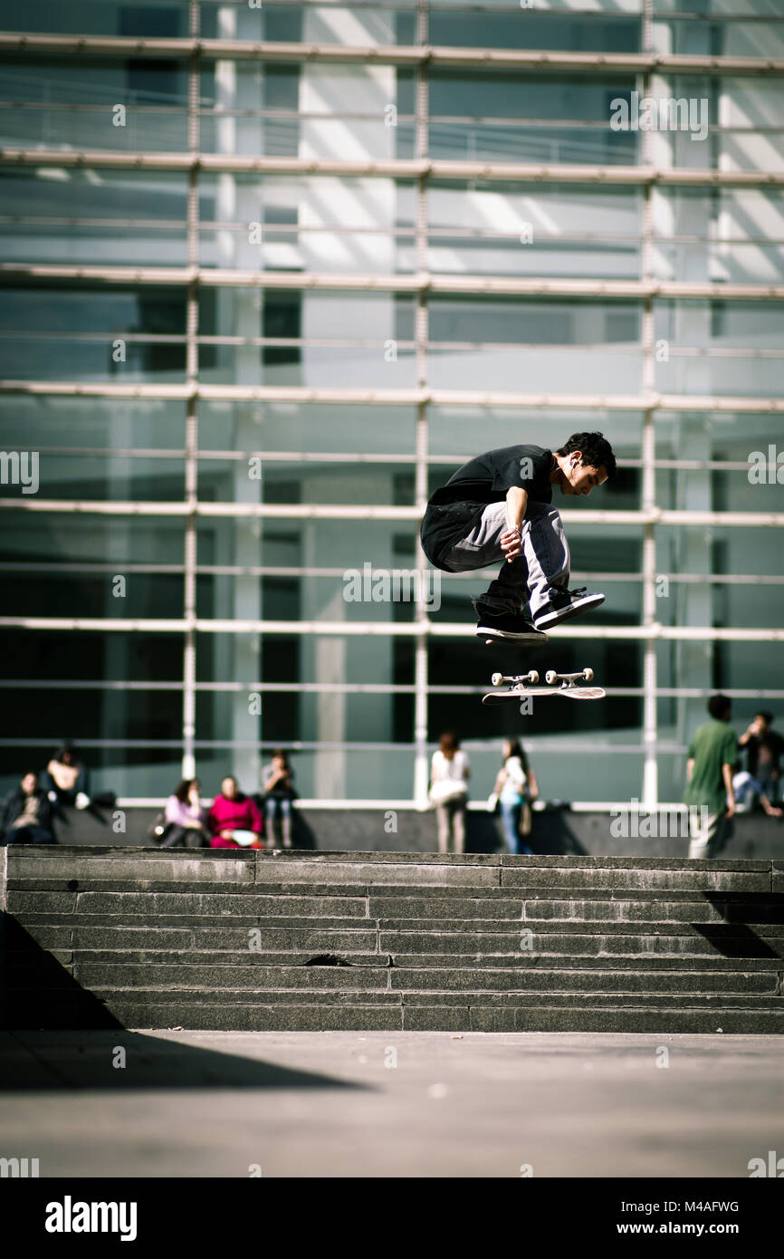 A skater is flying through the air on his skateboard in Barcelona ...