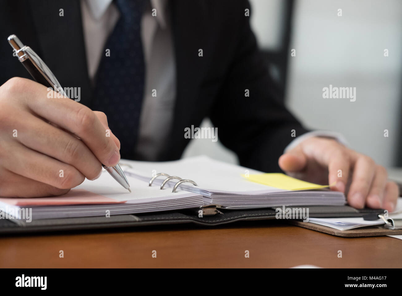 hand of businessman writing on paper at workplace. young male ...