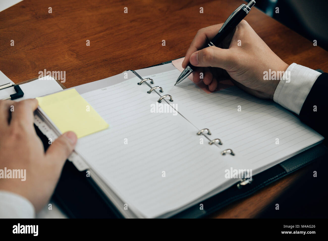 hand of businessman writing on paper at workplace. young male ...