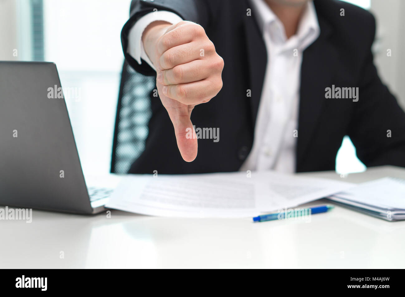 Business man showing thumbs down in office Stock Photo - Alamy
