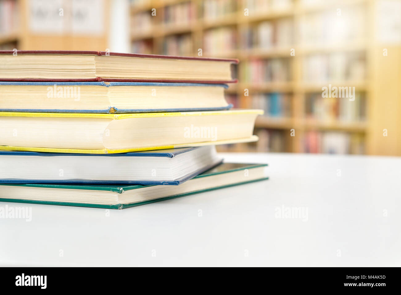 Stack and pile of books on table in public or school library. Education ...