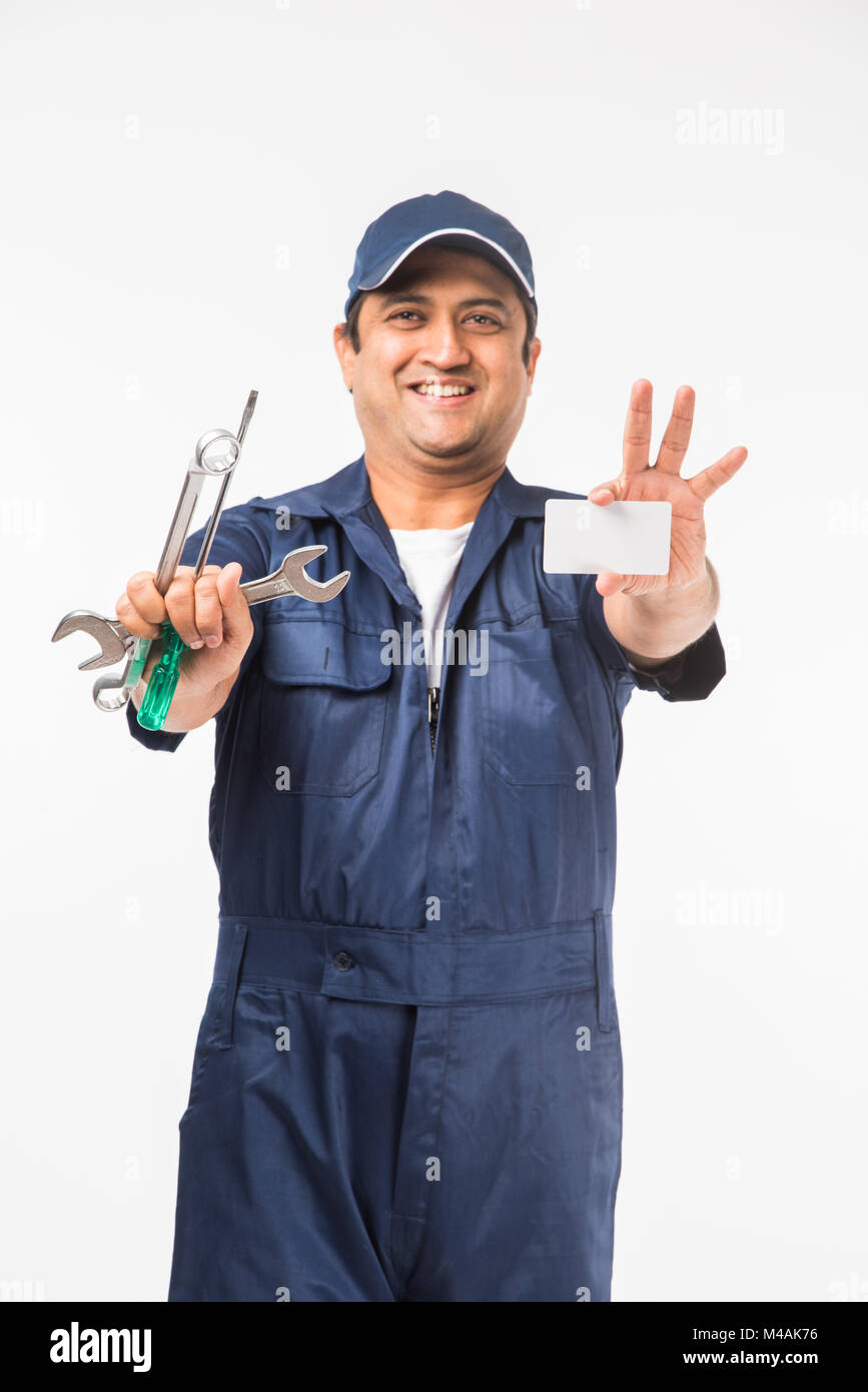 Indian happy auto mechanic in blue suit and cap holding spanner tool in ...