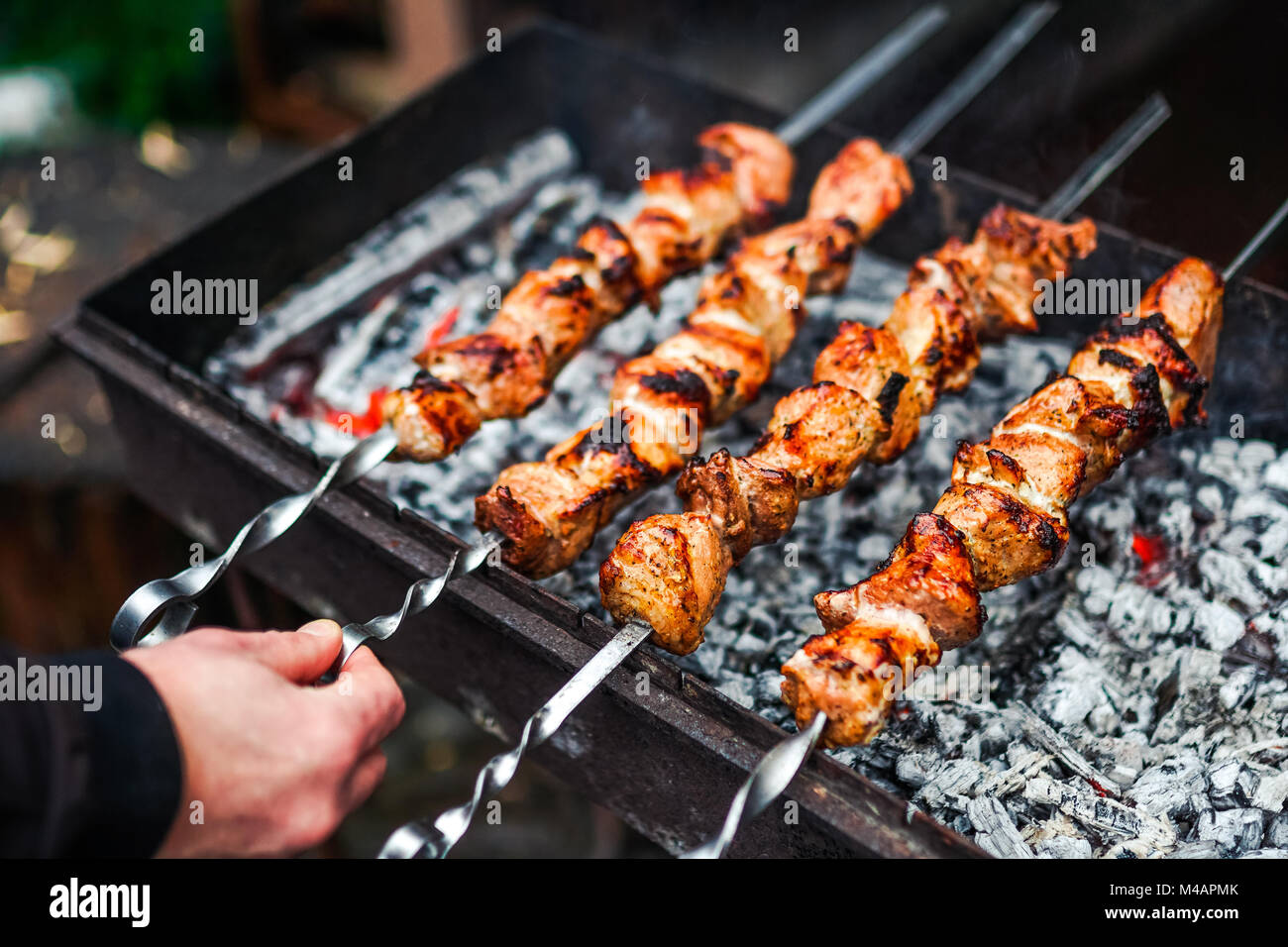 Grilled kebab cooking on metal skewer. Roasted meat cooked at barbecue ...