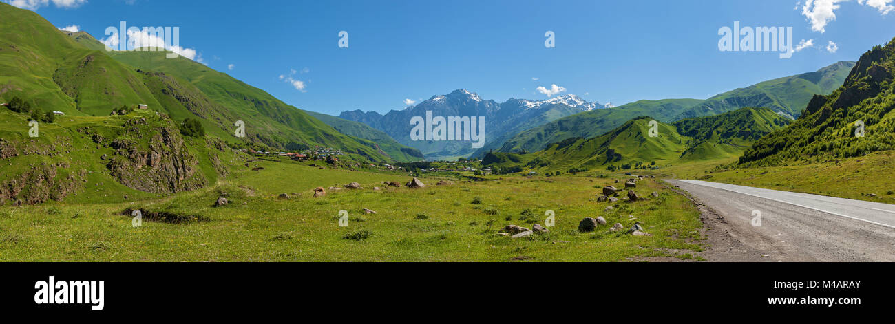 Military Georgian road against the background of green mountains ...