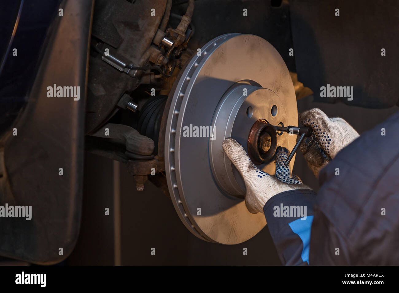 The man is repairing the disc brake in the car. Repair disc brake Stock ...