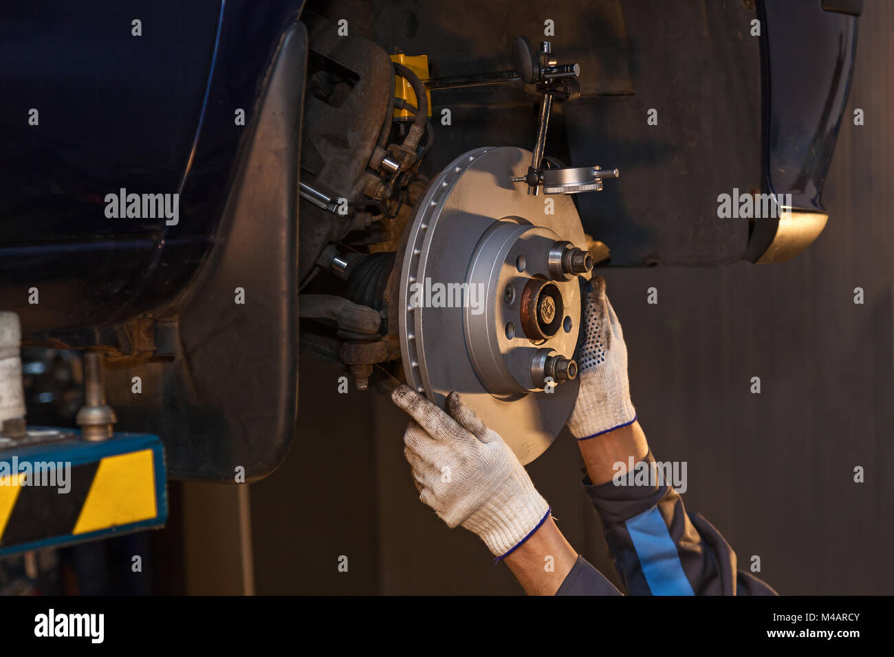 The man is repairing the disc brake in the car. Repair disc brake Stock ...