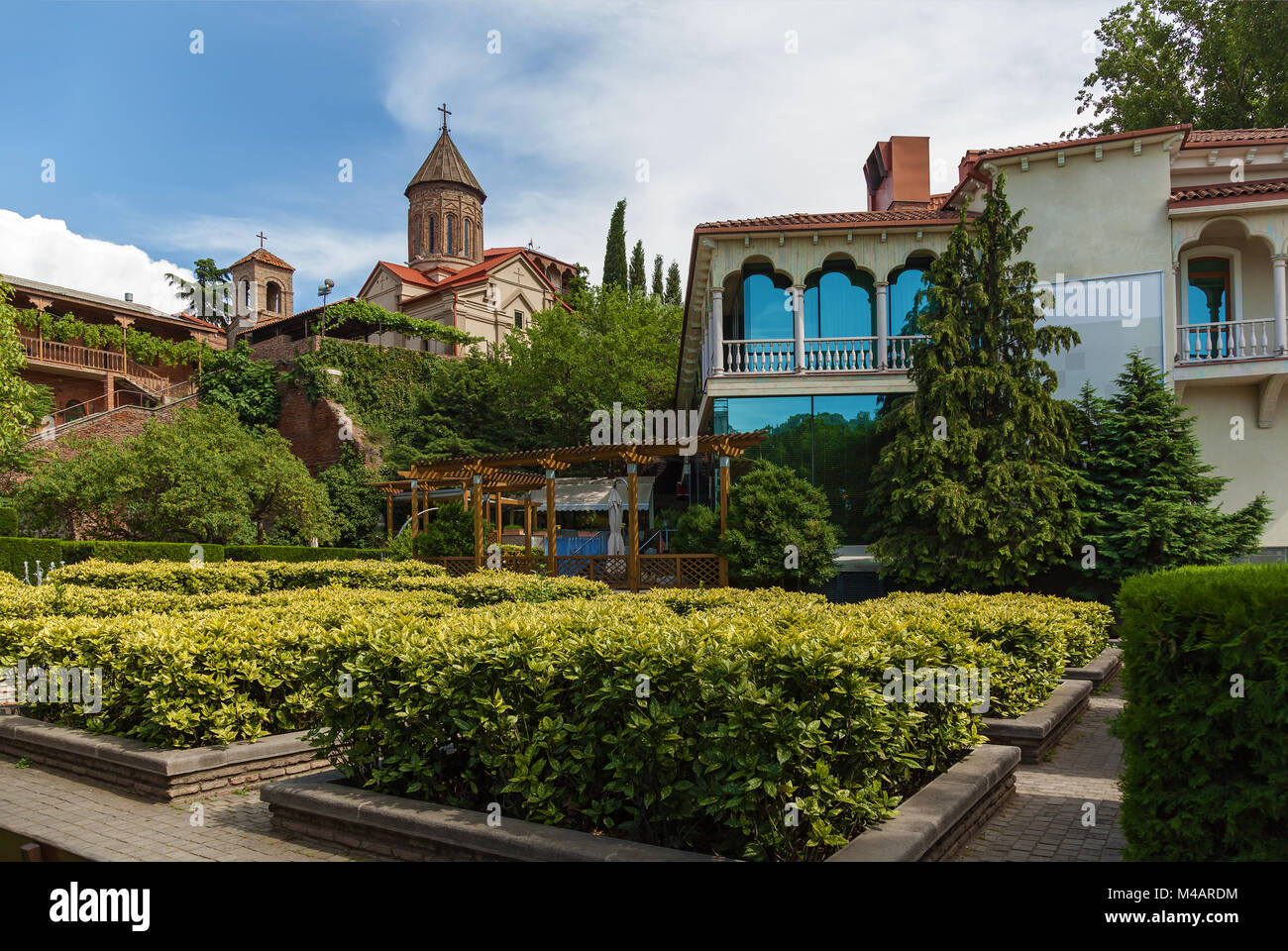 The benches, bushes, trees on the background of the hotel. Alley ...