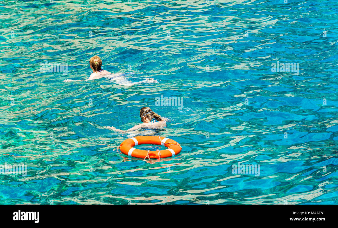 Two women floating in the sea near the lifeline Stock Photo - Alamy