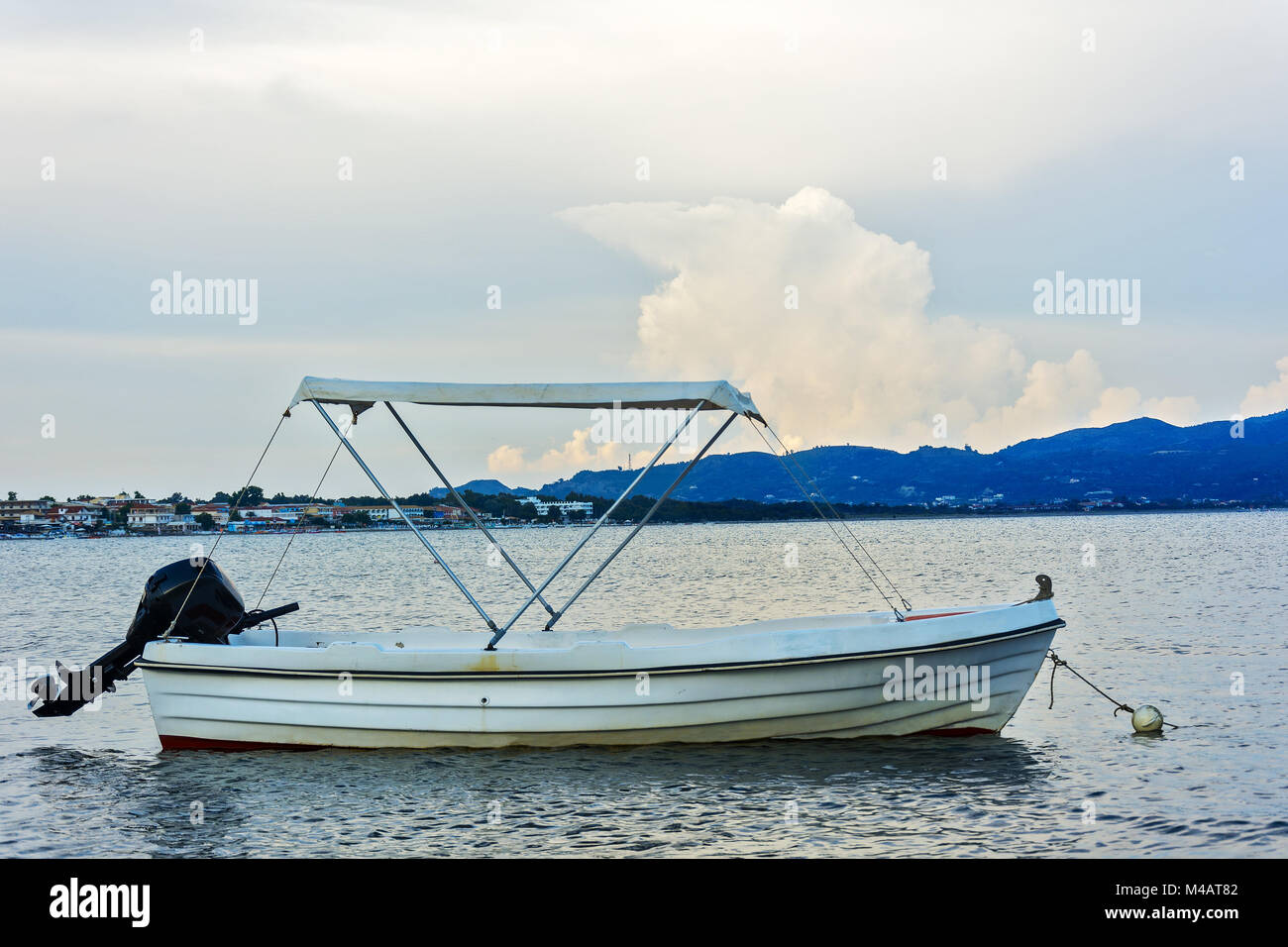 Motor boat with awning on coast background moored at anchor Stock Photo ...