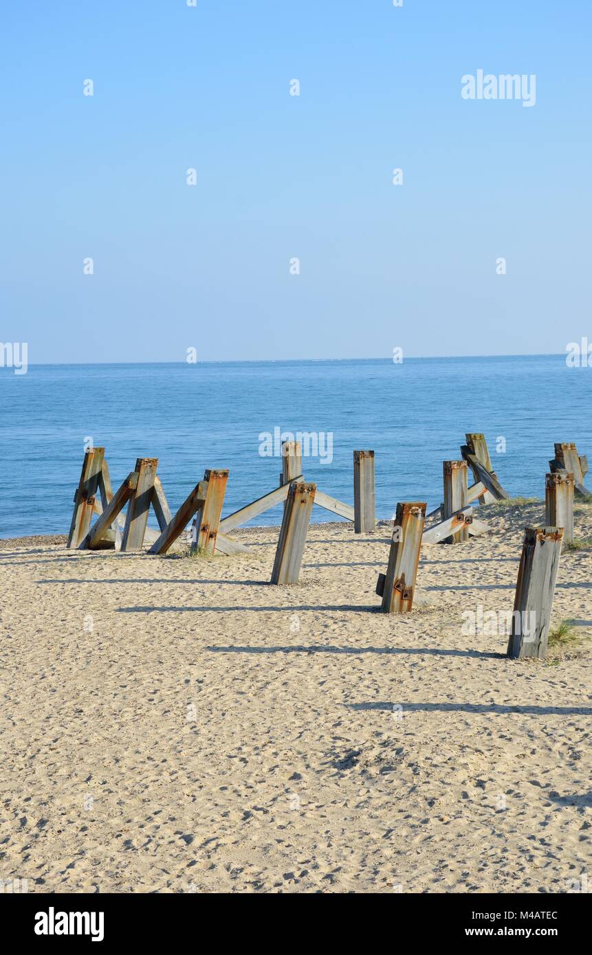 Weathered wooden posts in ground by the sea in portrait Stock Photo - Alamy