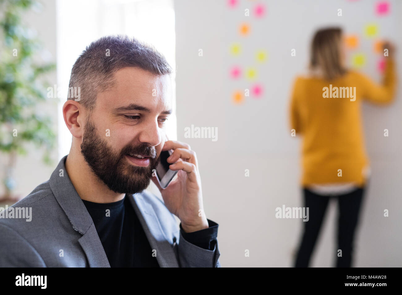 Two business people with smartphone in the office Stock Photo - Alamy