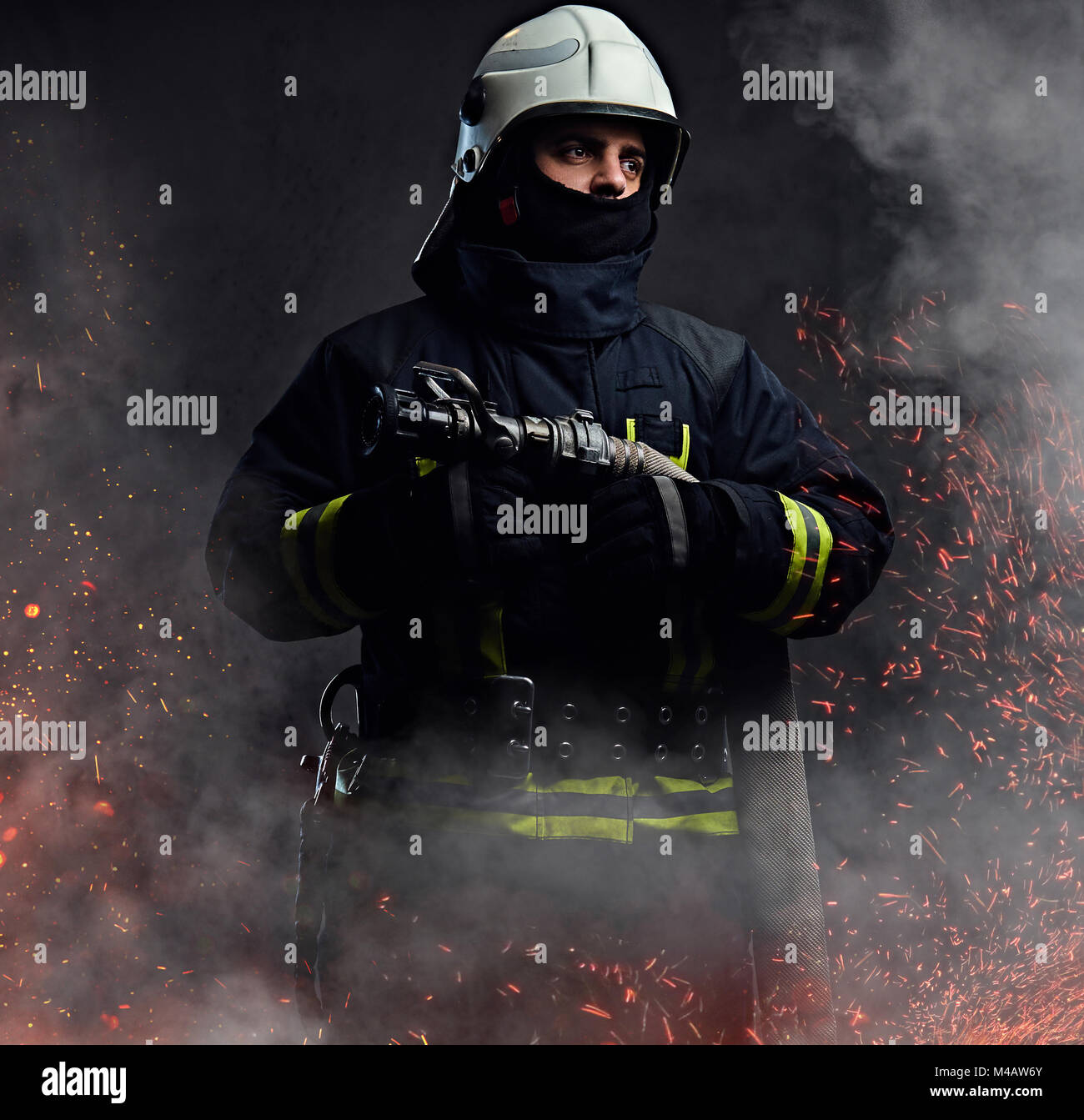 A firefighter dressed in a uniform in a studio Stock Photo - Alamy