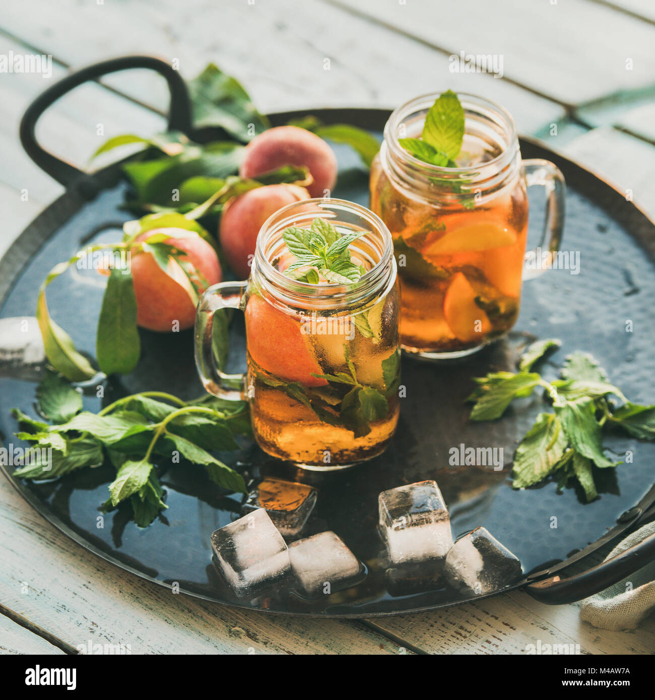 Summer refreshing cold peach ice tea on tray, square crop Stock Photo ...