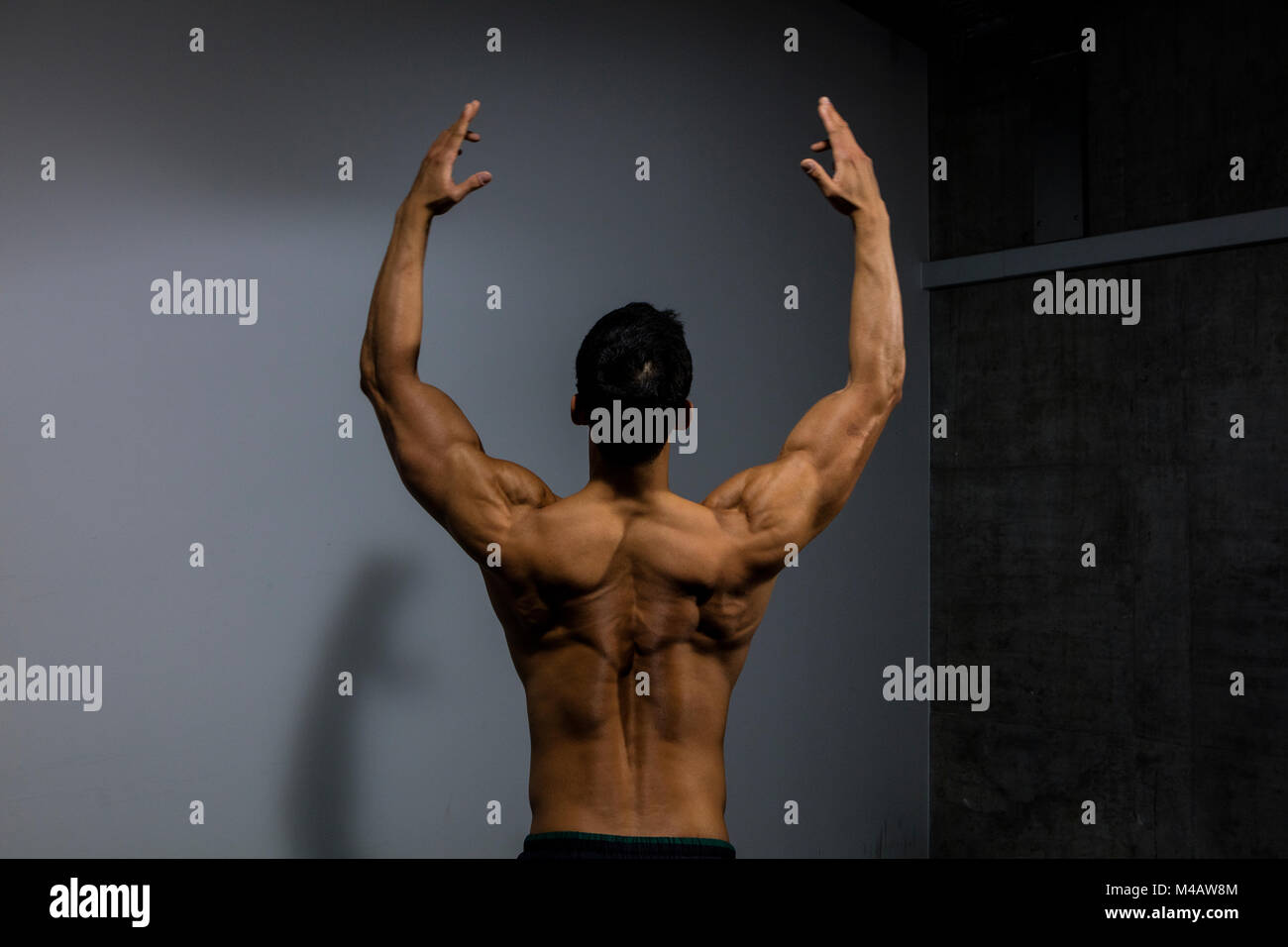 A male fitness model displays his back muscles. Medium shot Stock Photo ...
