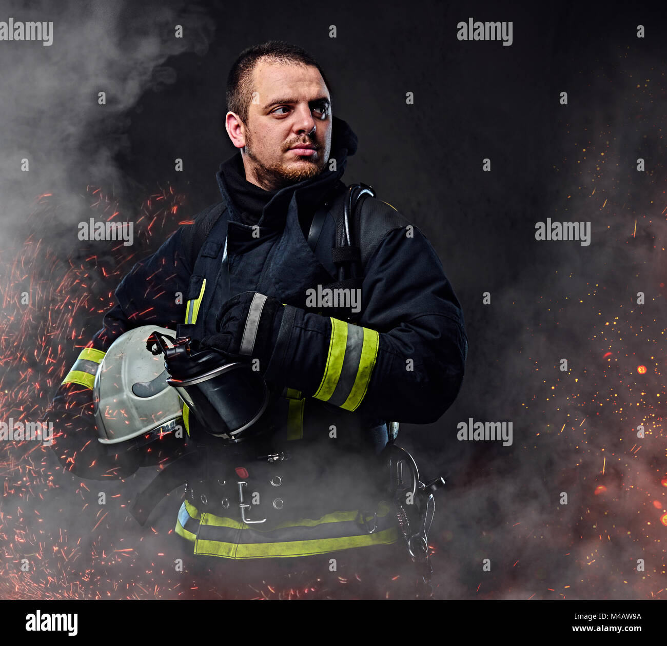 A firefighter dressed in a uniform in a studio Stock Photo - Alamy