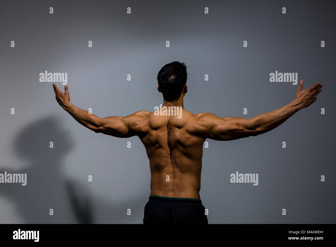 A male fitness model displays his back muscles. Medium shot Stock Photo ...