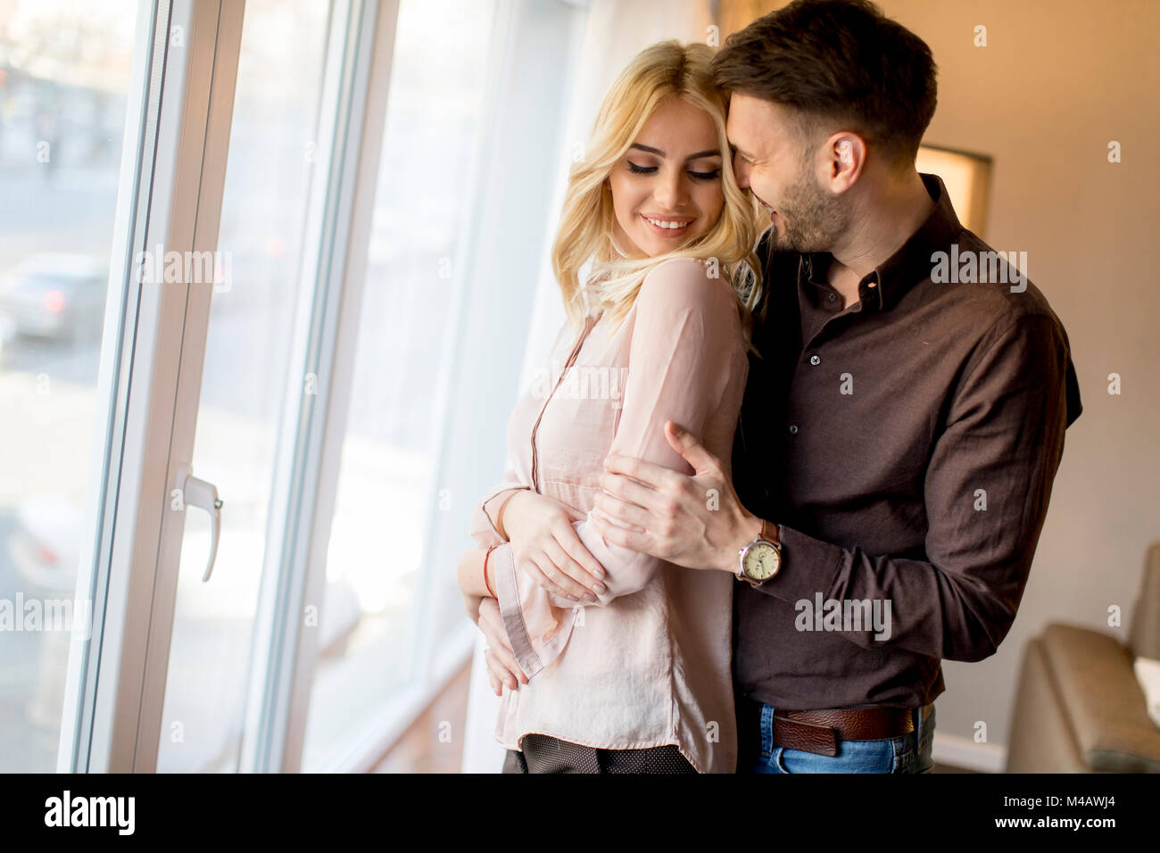 Portrait of the loving couple by window in the room Stock Photo - Alamy