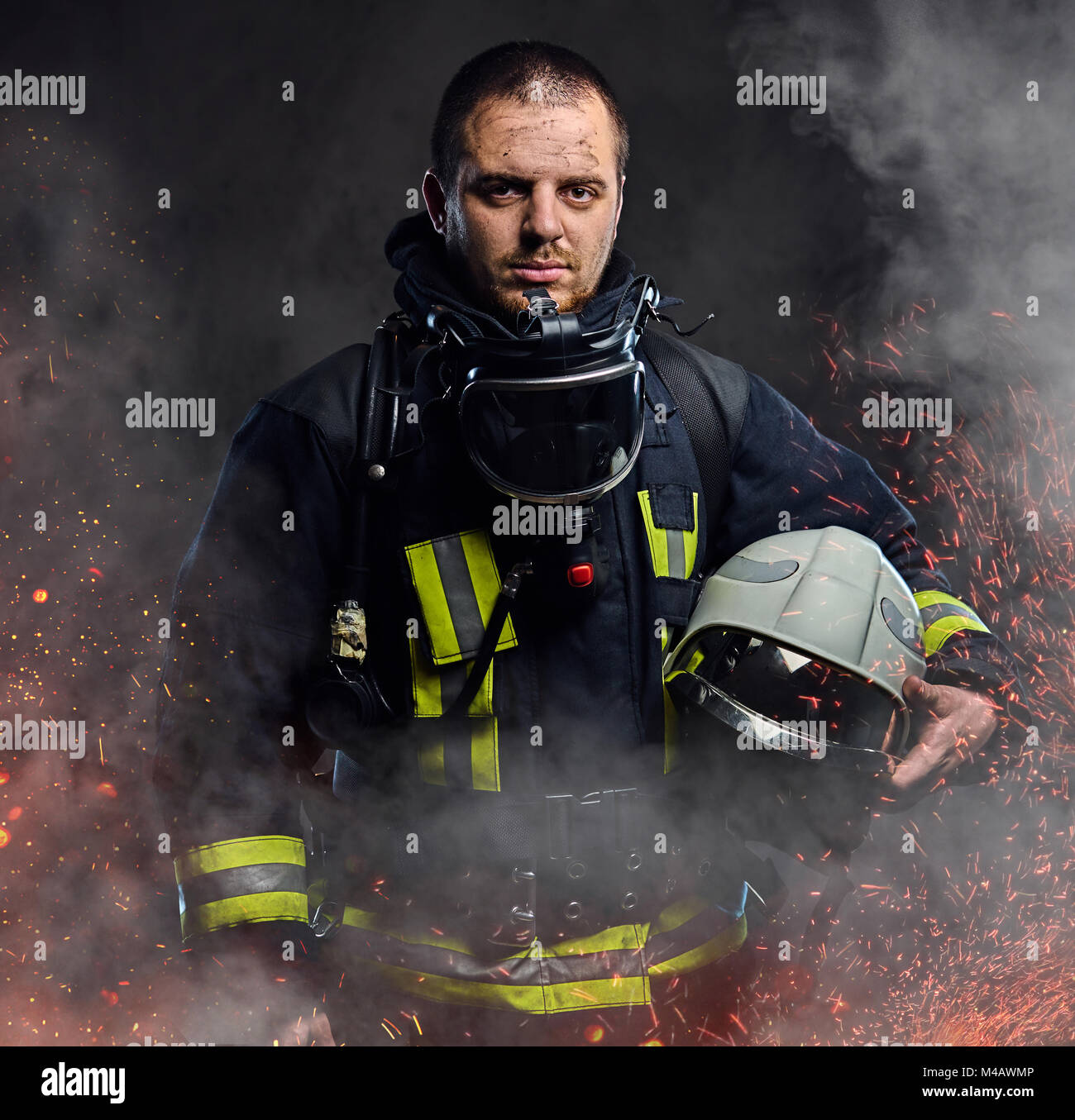 A firefighter dressed in a uniform in a studio Stock Photo - Alamy