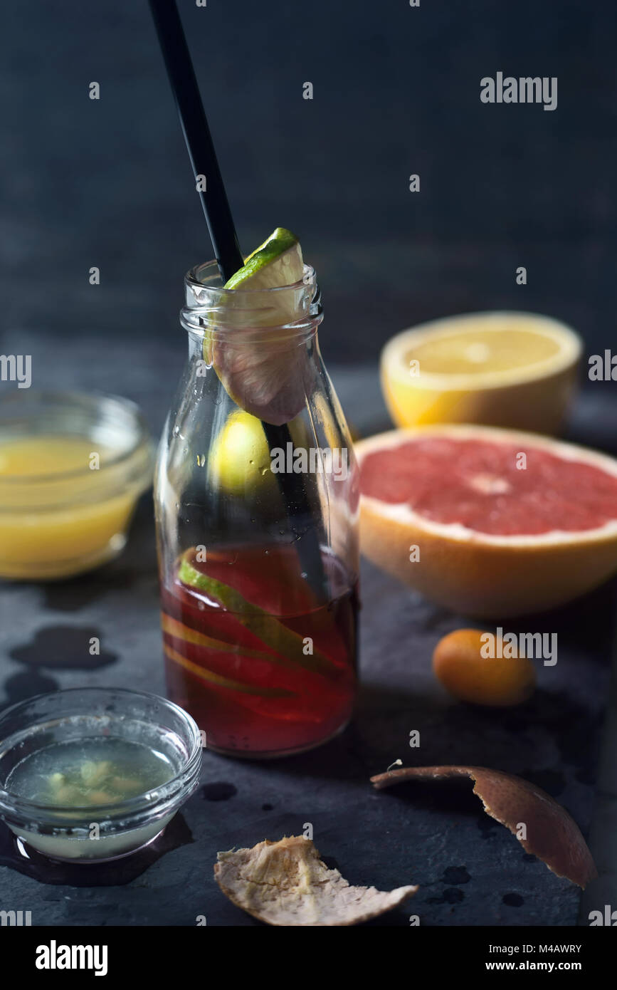 Half-empty bottle with citrus juice on the dark stone background Stock ...