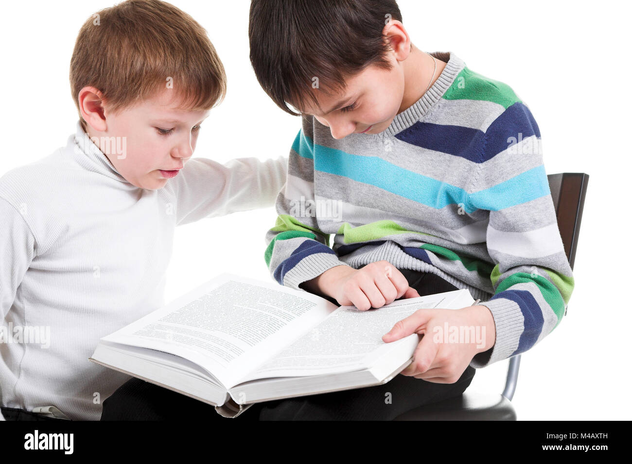 Two boys reading big book Stock Photo - Alamy