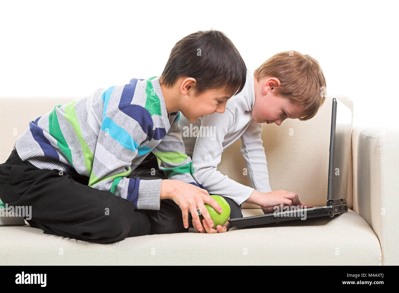 Two boys with laptop on the sofa Stock Photo - Alamy