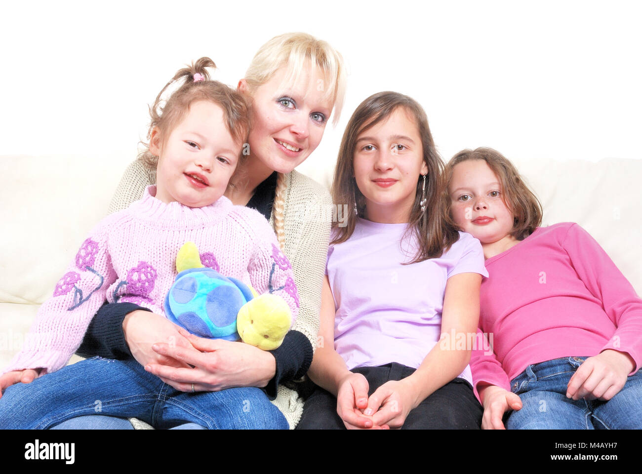 Family sitting in living room on sofa Stock Photo - Alamy