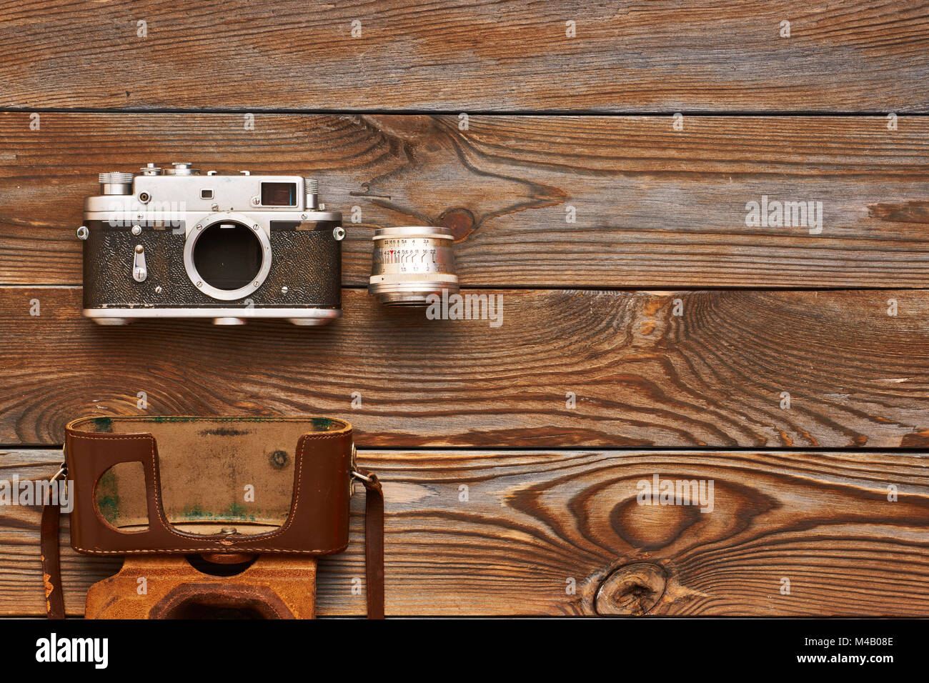 Vintage old camera and lens on wooden background Stock Photo - Alamy