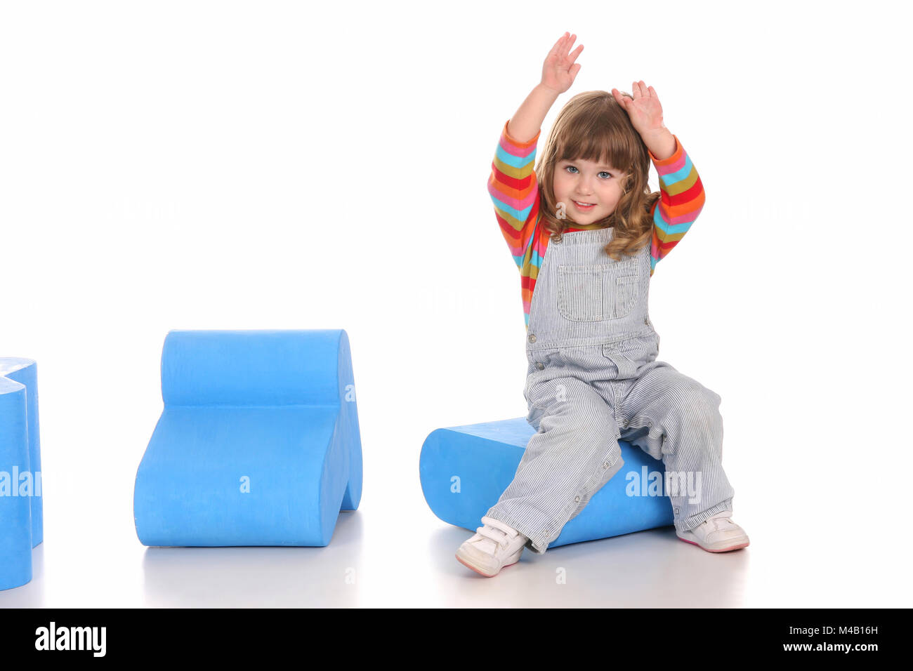 beauty a little girl sitting on blue toy box Stock Photo - Alamy