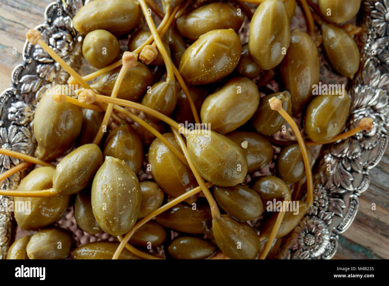 Pickled caper berries in metal dish . Edible fruits of Capparis ...