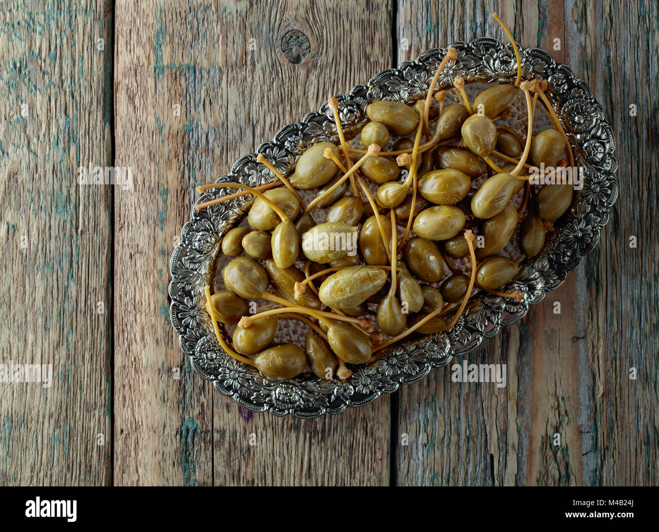 Pickled caper berries in metal dish . Edible fruits of Capparis ...