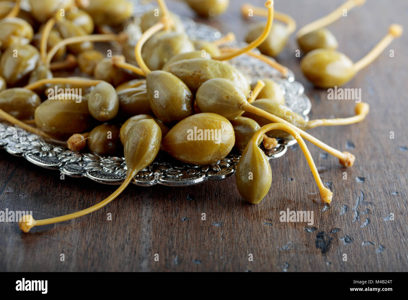 Pickled caper berries in metal dish . Edible fruits of Capparis ...