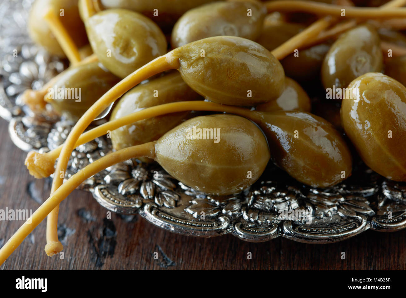 Pickled caper berries in metal dish . Edible fruits of Capparis ...