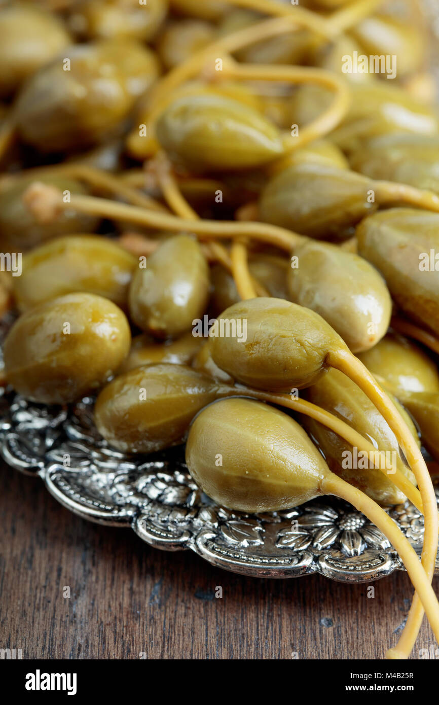 Pickled caper berries in metal dish . Edible fruits of Capparis ...