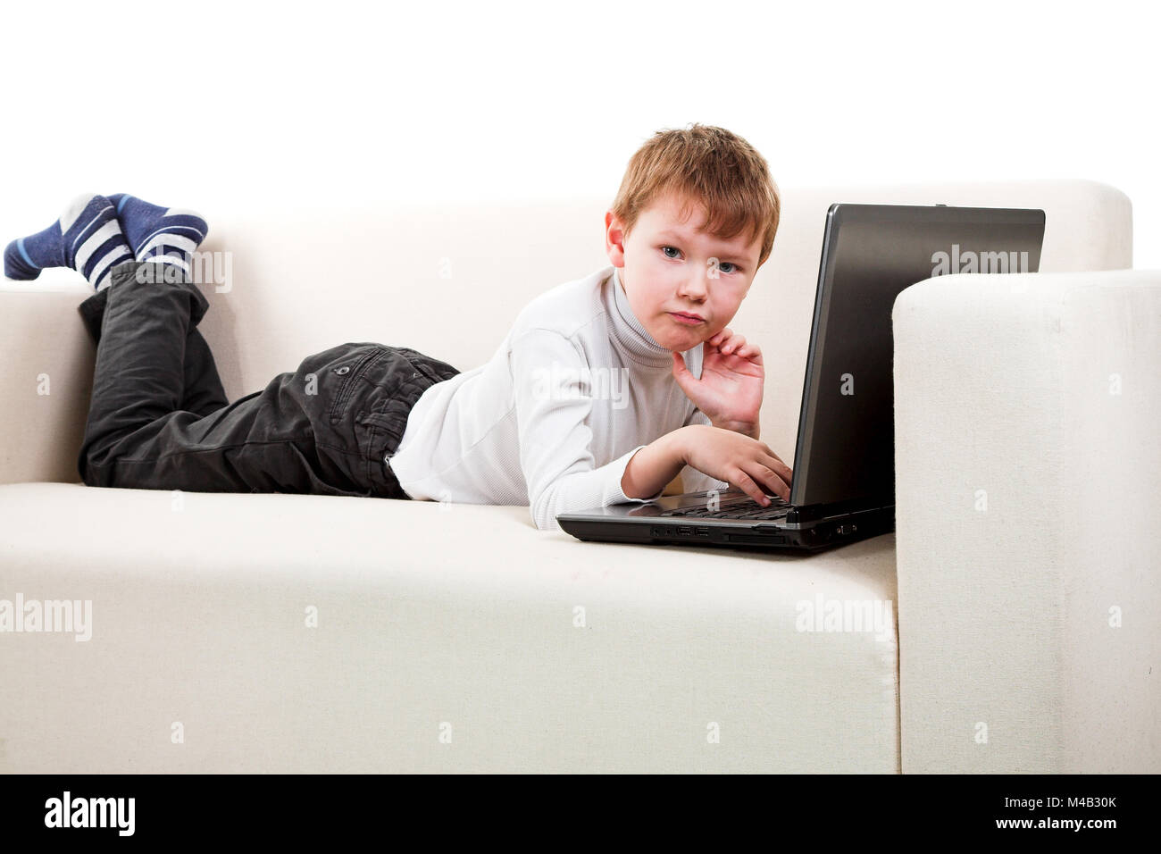 Two boys with laptop on the sofa Stock Photo - Alamy
