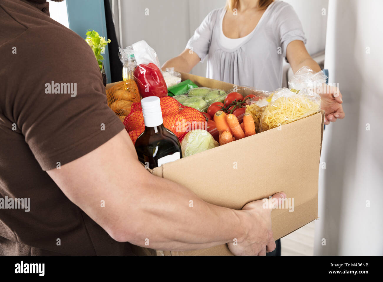 Close-up Of A Delivery Man Giving Grocery Cardboard Box To Woman Stock ...