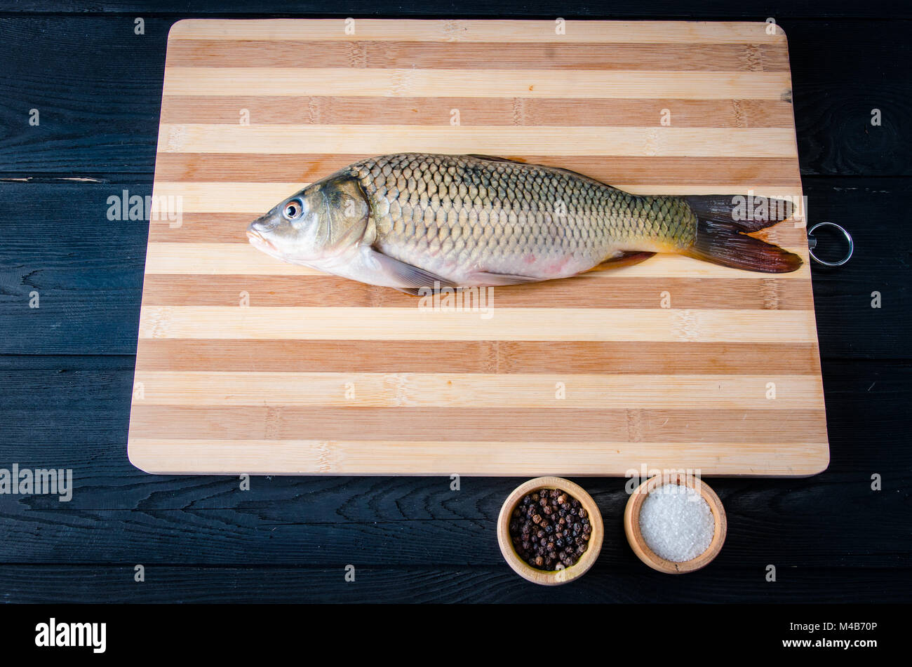 Uncooked fish on cutting board in meal preparation concept Stock Photo ...