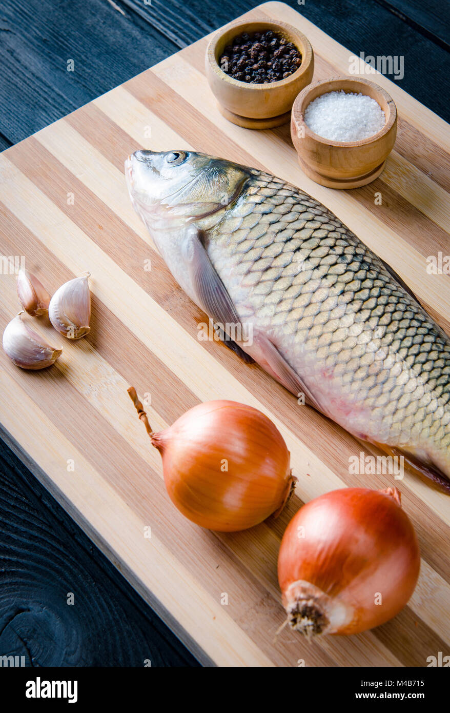 Uncooked fish on cutting board in meal preparation concept Stock Photo ...