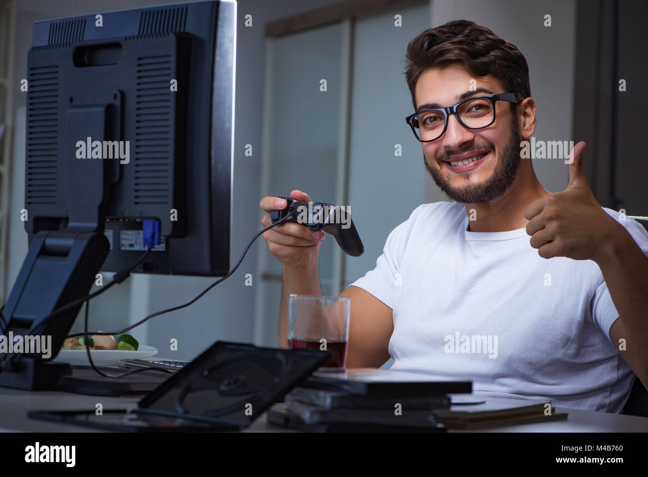 Young man playing games long hours late in the office Stock Photo - Alamy