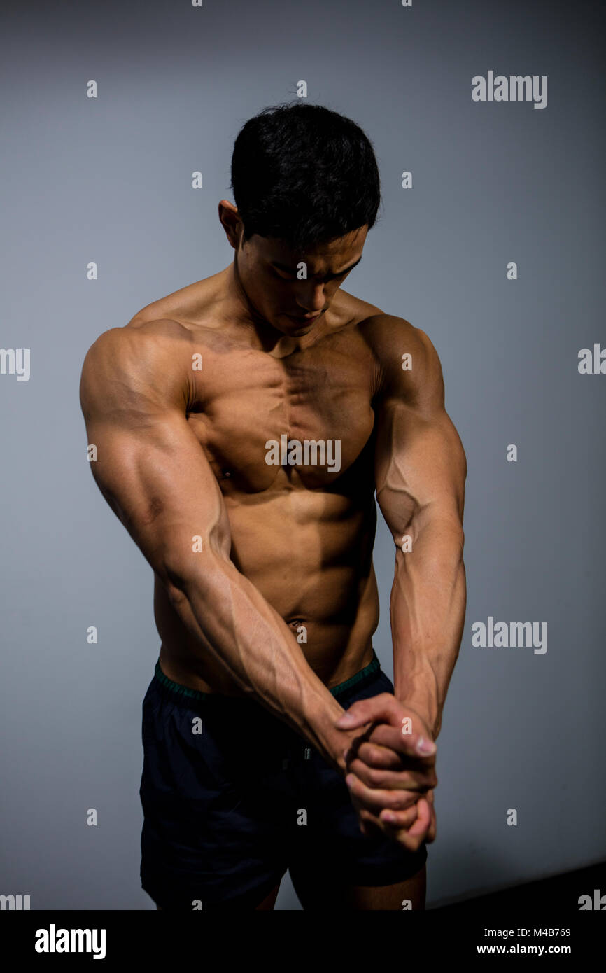 A fitness model flexing his pectoral muscles. Medium shot Stock Photo ...