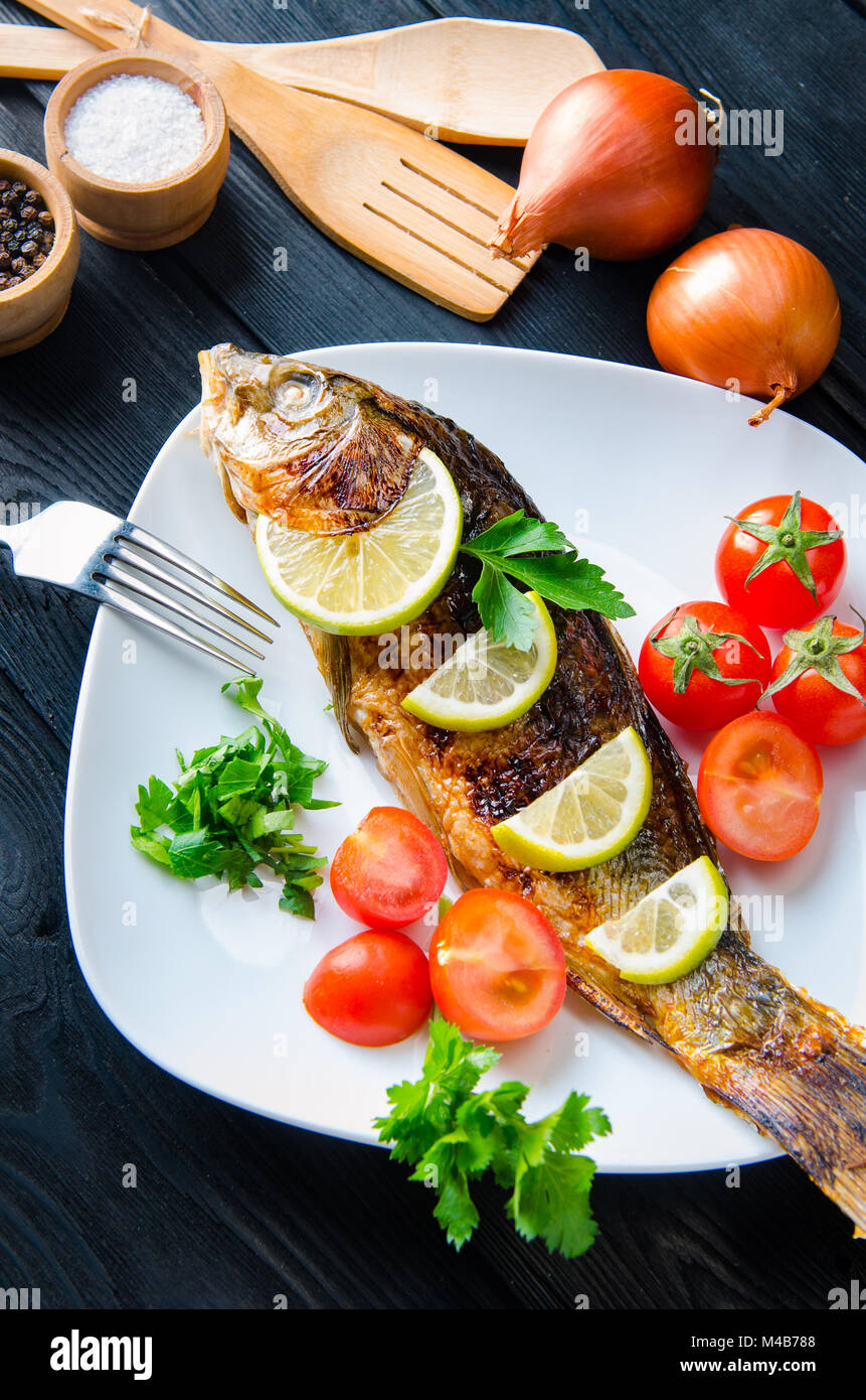Fried fish served on the plate Stock Photo - Alamy
