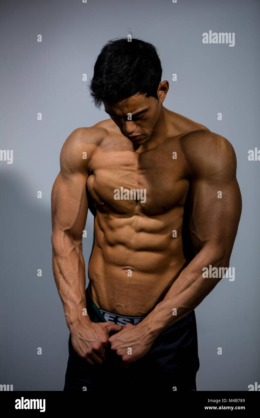 A fitness model flexing his pectoral muscles. Medium shot Stock Photo ...