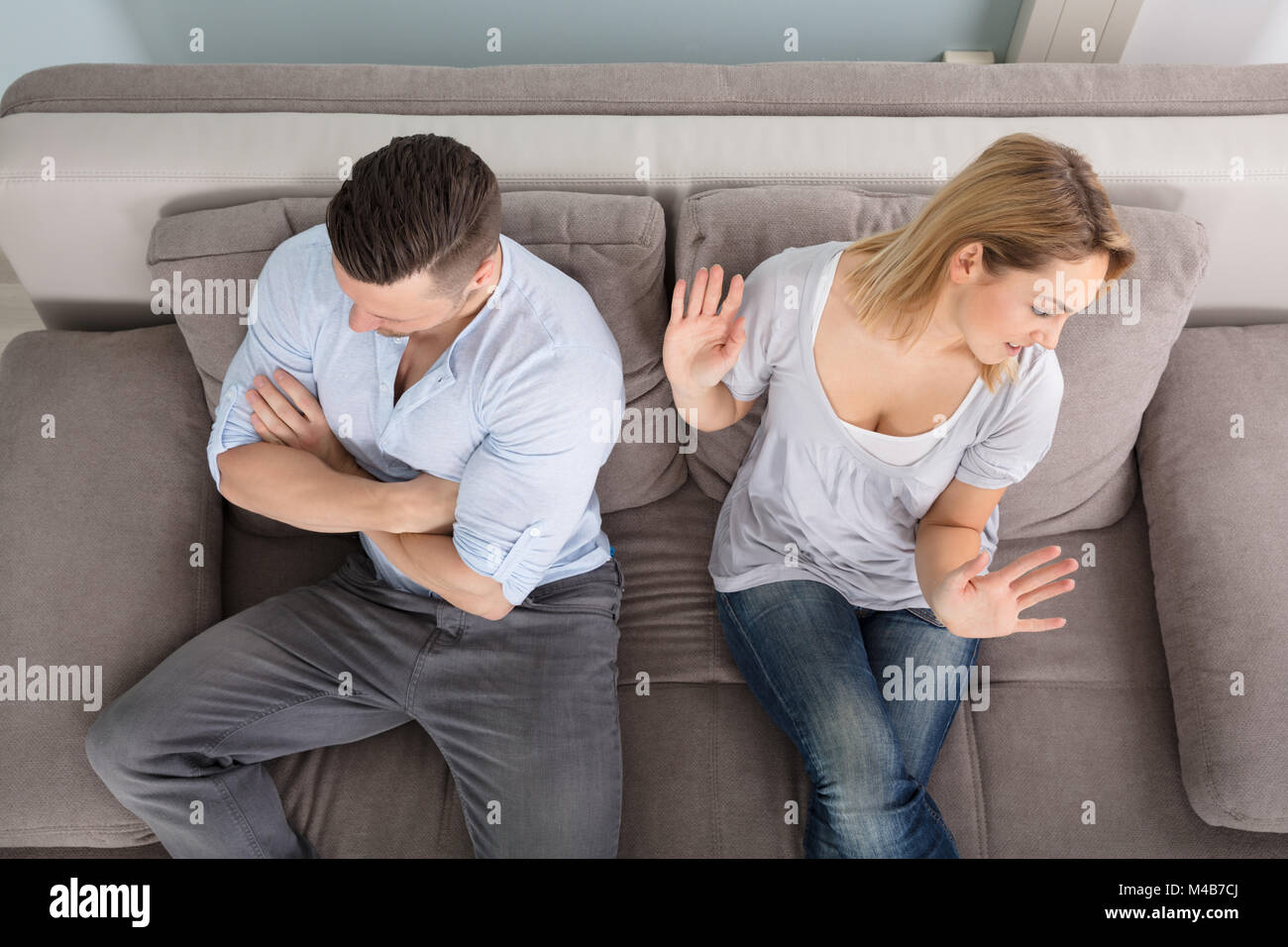 Overhead View Of A Couple Sitting On Couch Having Discussion At Home ...