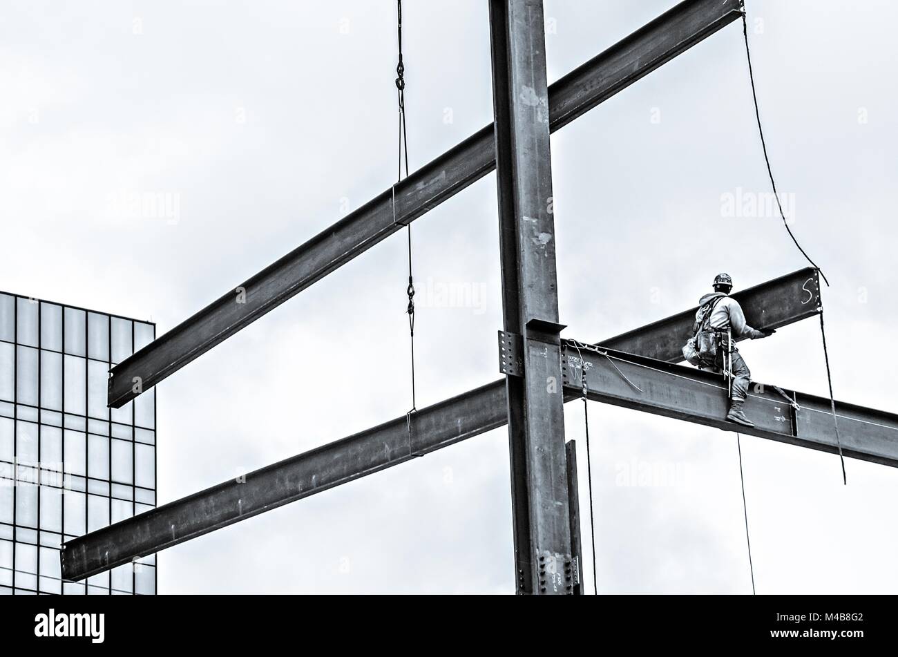construction worker working on highrise building Stock Photo - Alamy