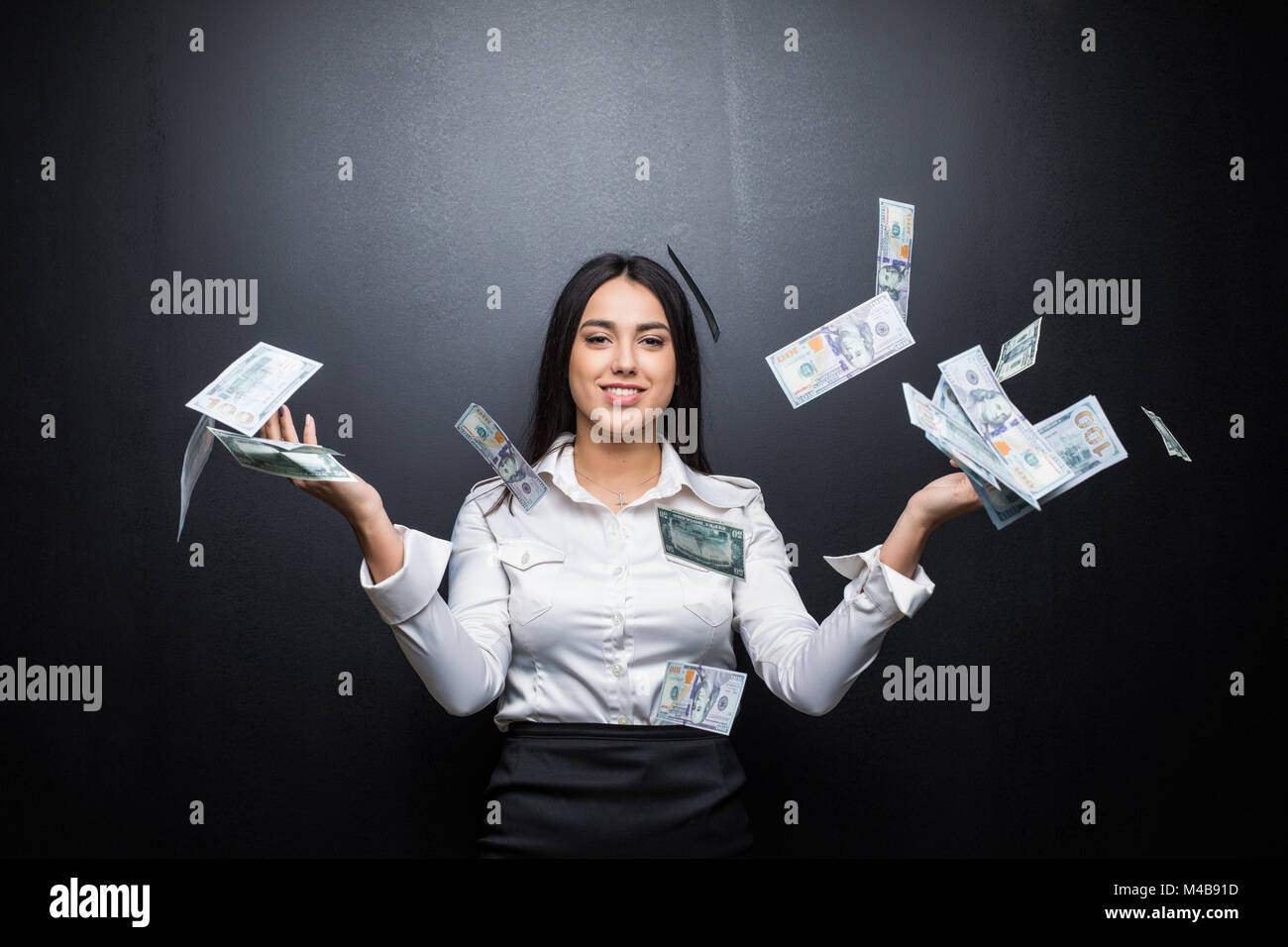Happy business woman under a money rain made of dollars isolated on ...